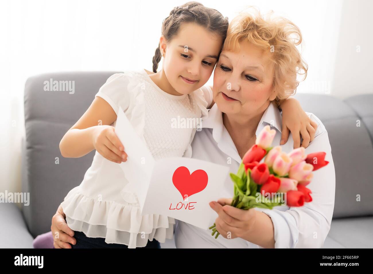 Sincere cute little granddaughter strong cuddling and kissing in cheek ...