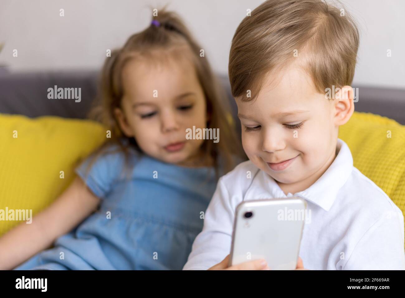 happy and sad little cute preschool siblings baby boy and child girl ...