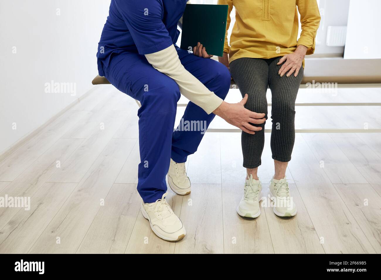 Osteopath examines a senior woman's leg in a rehab medical center ...