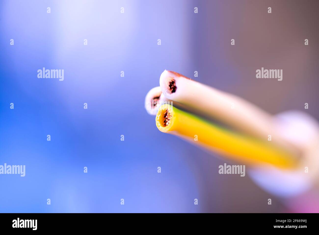 Electric cable without insulation, on a blue background with place for ...