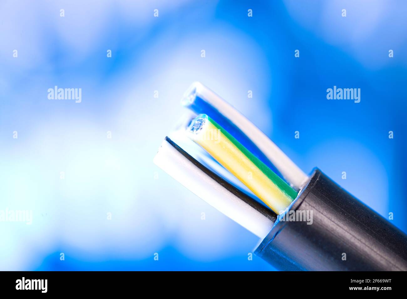 Electric cable without insulation, on a blue background with place for ...