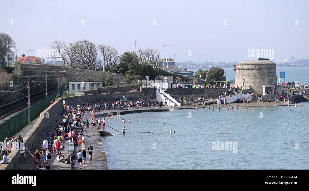 People enjoy the warm weather at a swimming spot by the Martello Tower ...