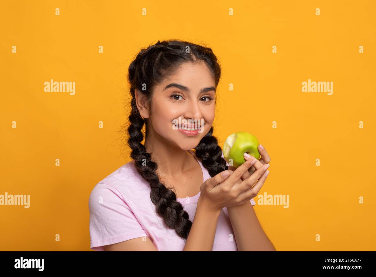 Portrait of a cheerful young woman holding bitten green apple Stock ...