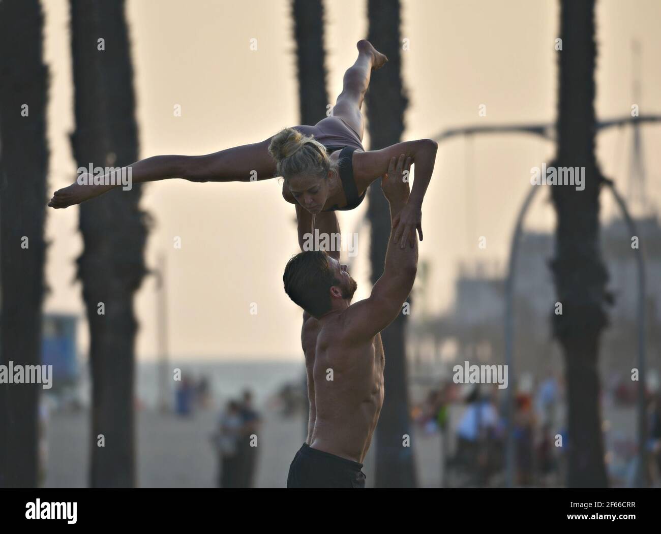Sunset landscape with young athletes performing Acro Yoga at the ...