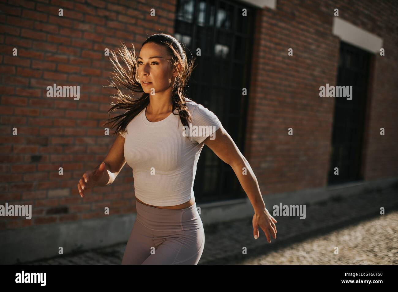 Pretty young woman running on the street Stock Photo - Alamy