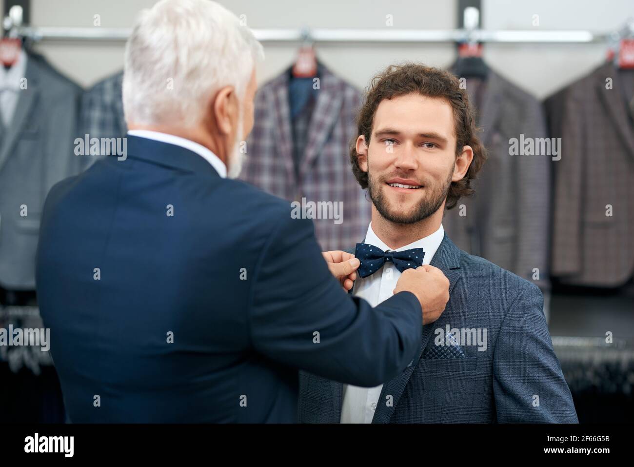 Happy clients picking up bow tie in store with suits. Concept of ...