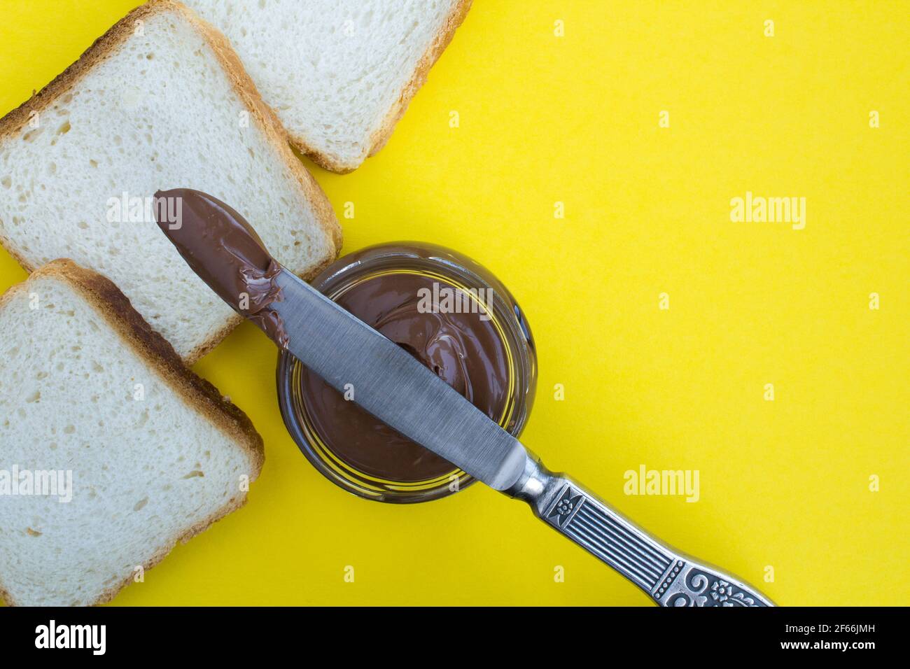 Chocolate cream, toast bread and knife on the yellow background.Top ...