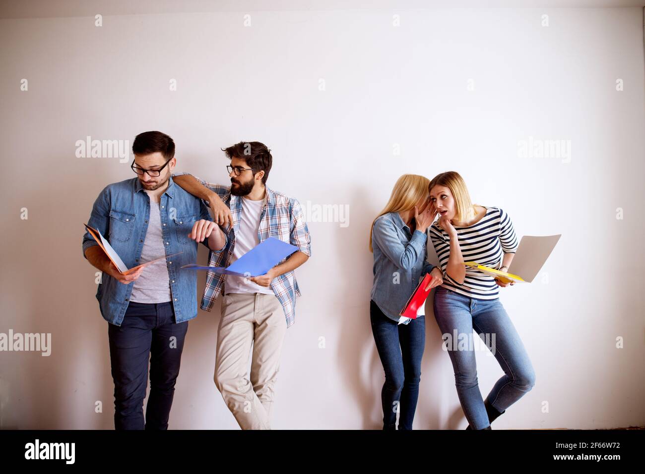 A group of guys and a group of females whispering separately while ...