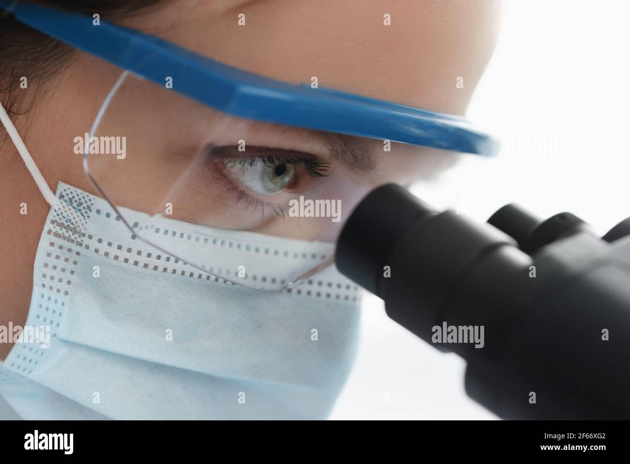Closeup woman looking through microscope hi-res stock photography and ...