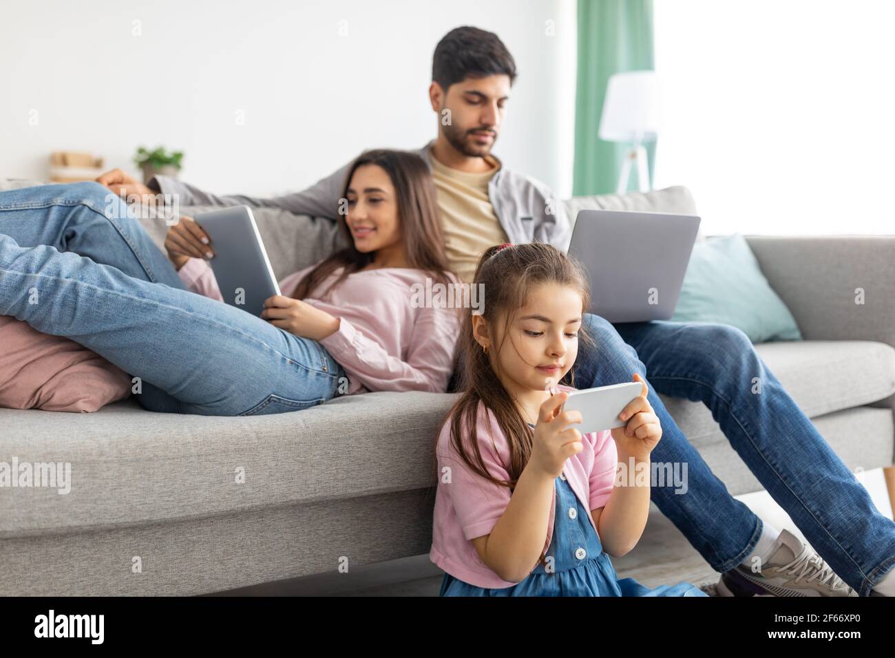 Family using electronic gadgets hi-res stock photography and images - Alamy