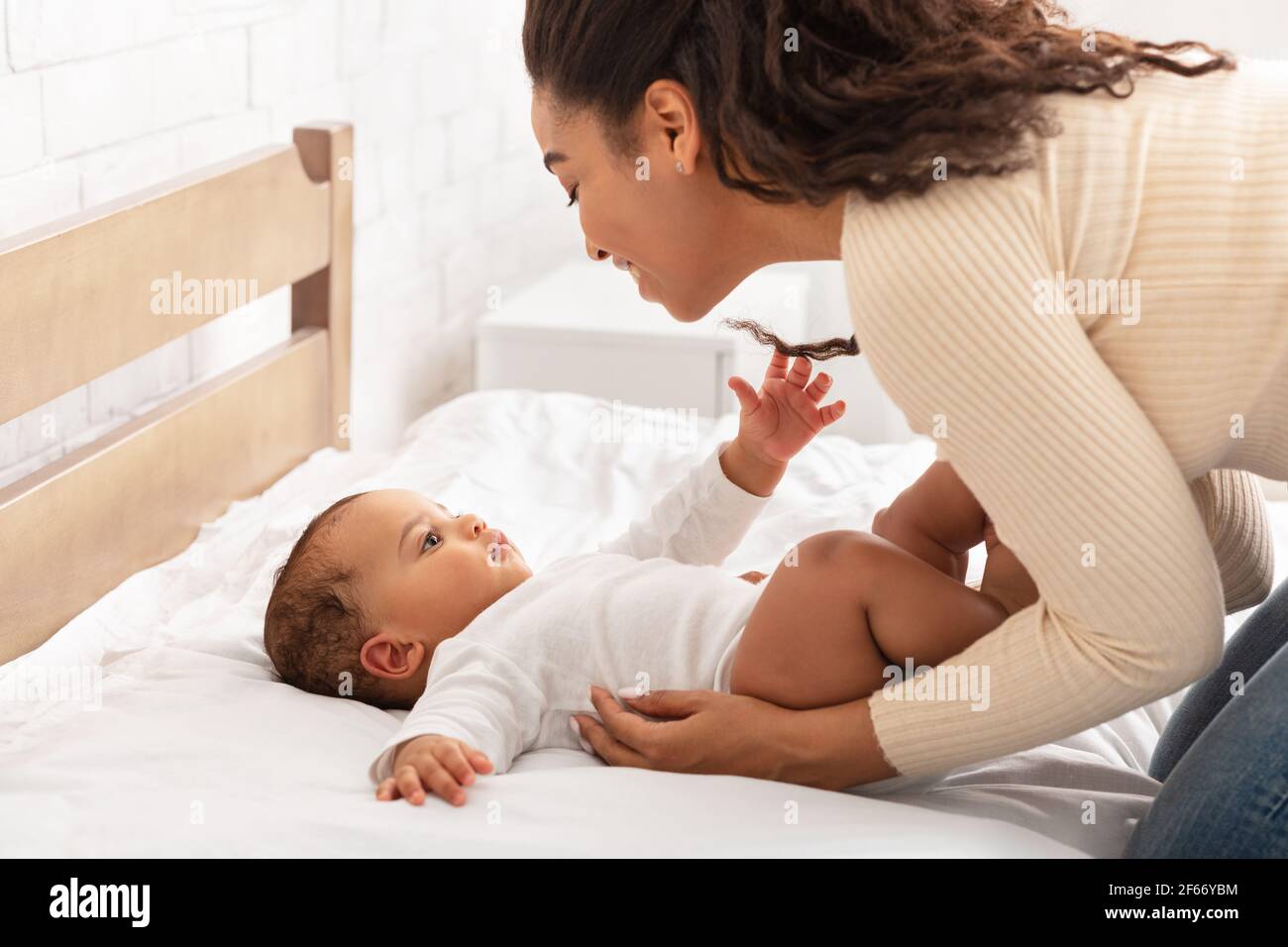 Black Mother Waking Up Her Baby Toddler After Sleep Indoor Stock Photo ...