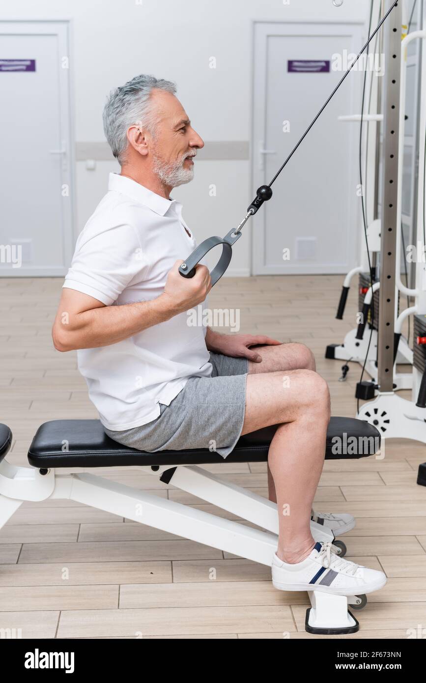 side view of smiling man working out in rehabilitation center Stock ...