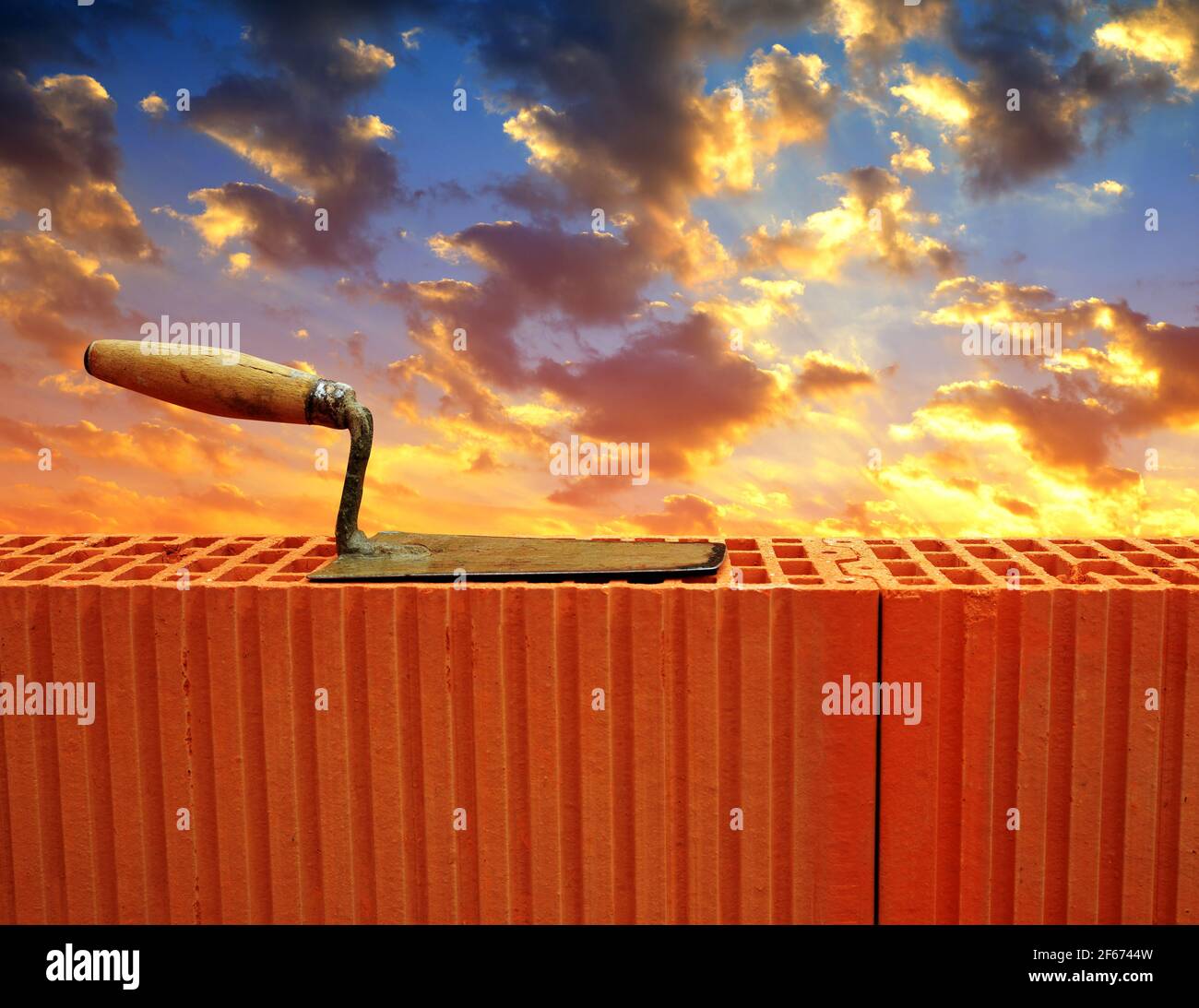 Trowel on brick wall in sunset. Masonry tools Stock Photo - Alamy