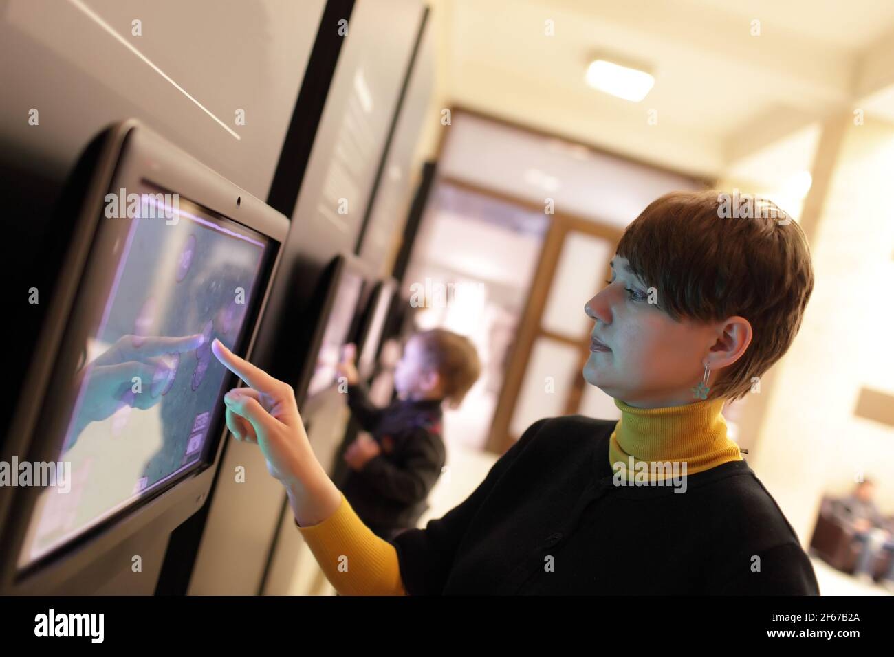 Woman using touch screen in a museum Stock Photo - Alamy
