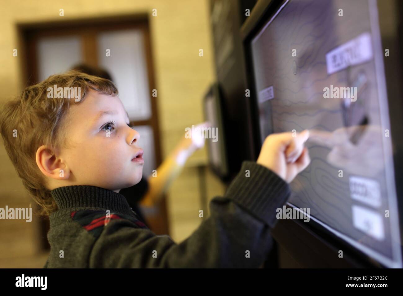 Child using interactive touch screen in a museum Stock Photo - Alamy