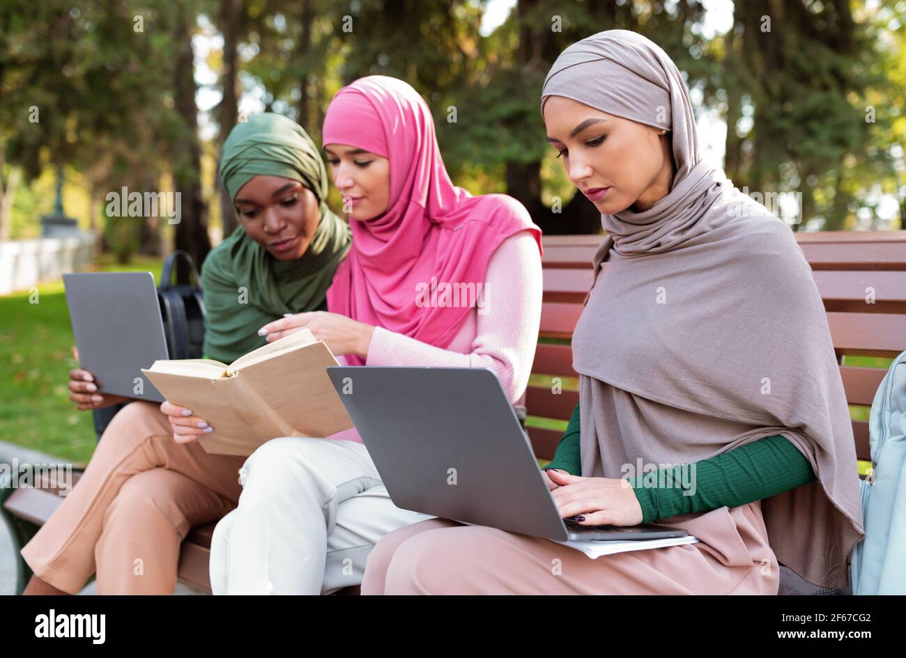 Three Islamic Women Learning Using Computers And Reading Books Outdoor ...