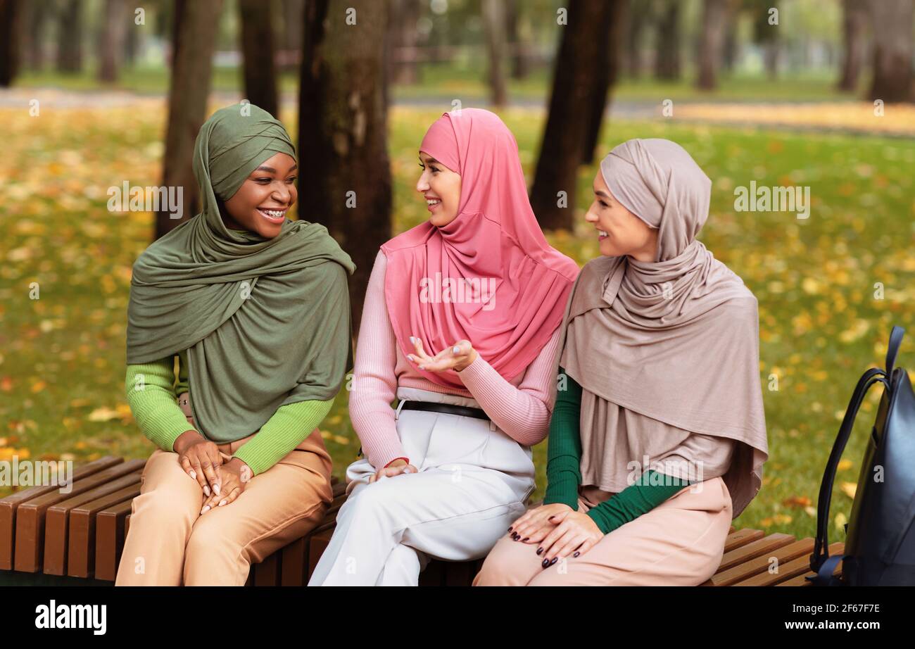 Muslim Young Women Talking Sitting On Bench In Park Outdoors Stock ...