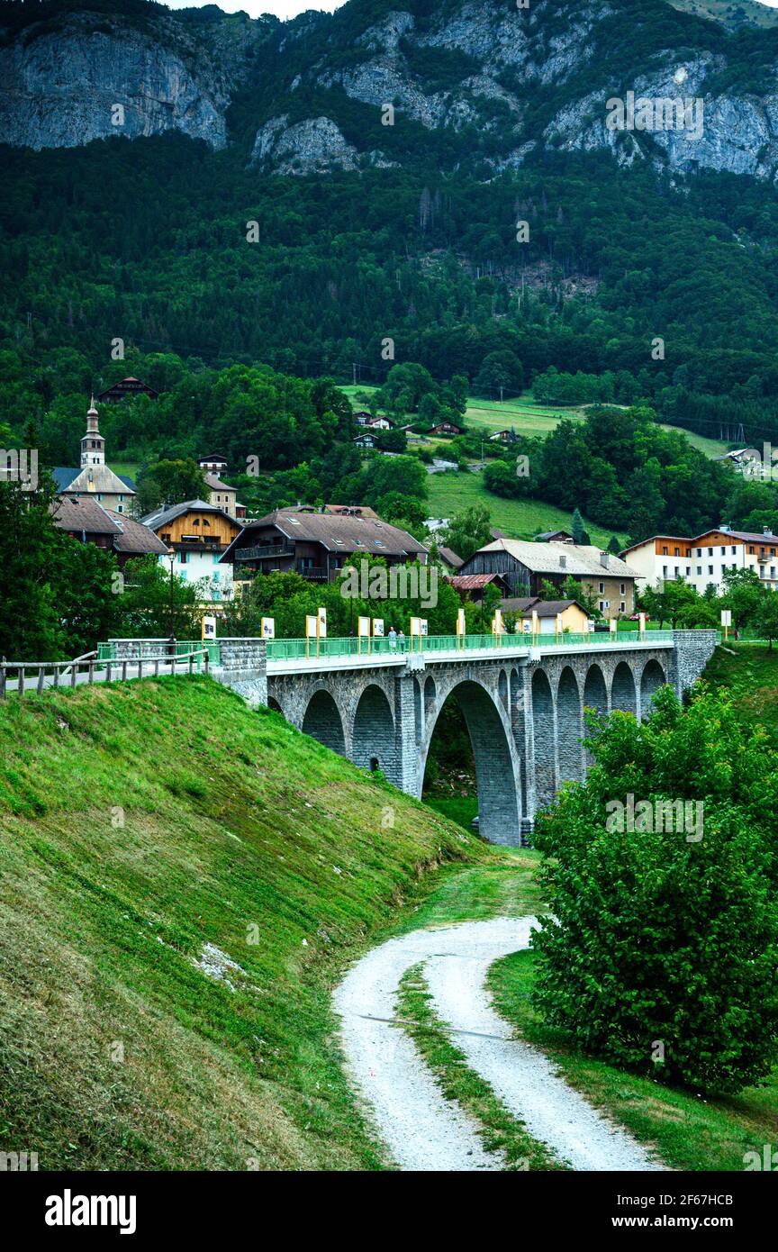 High and long stone bridge with multiple arches in Mieussy. Tall steep ...