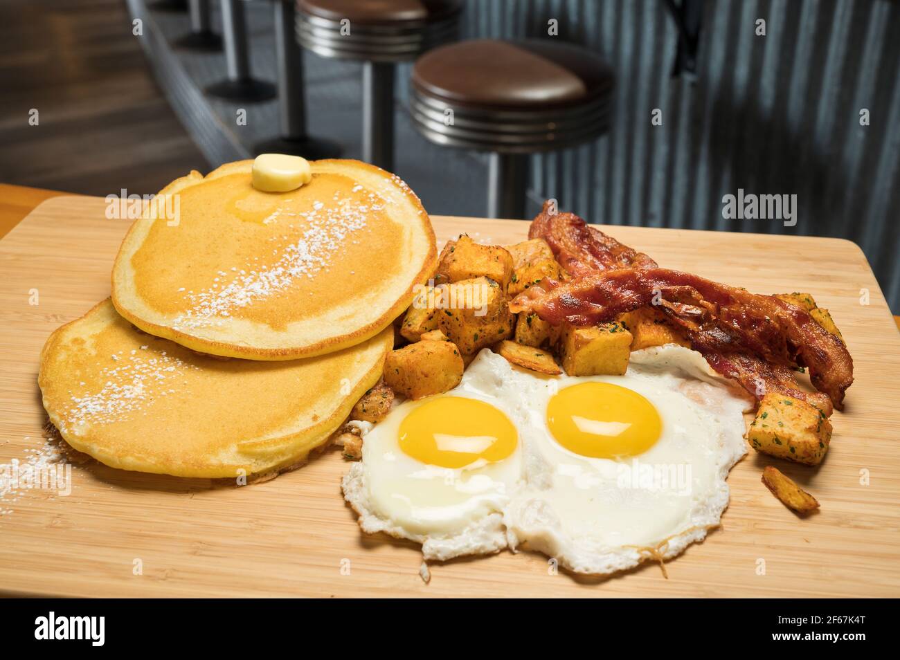 Diner style slam breakfast. Two eggs sunny side up, bacon, hash browns ...