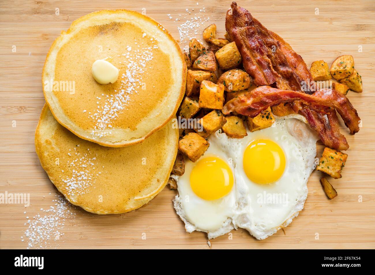 Diner style slam breakfast. Two eggs sunny side up, bacon, hash browns ...