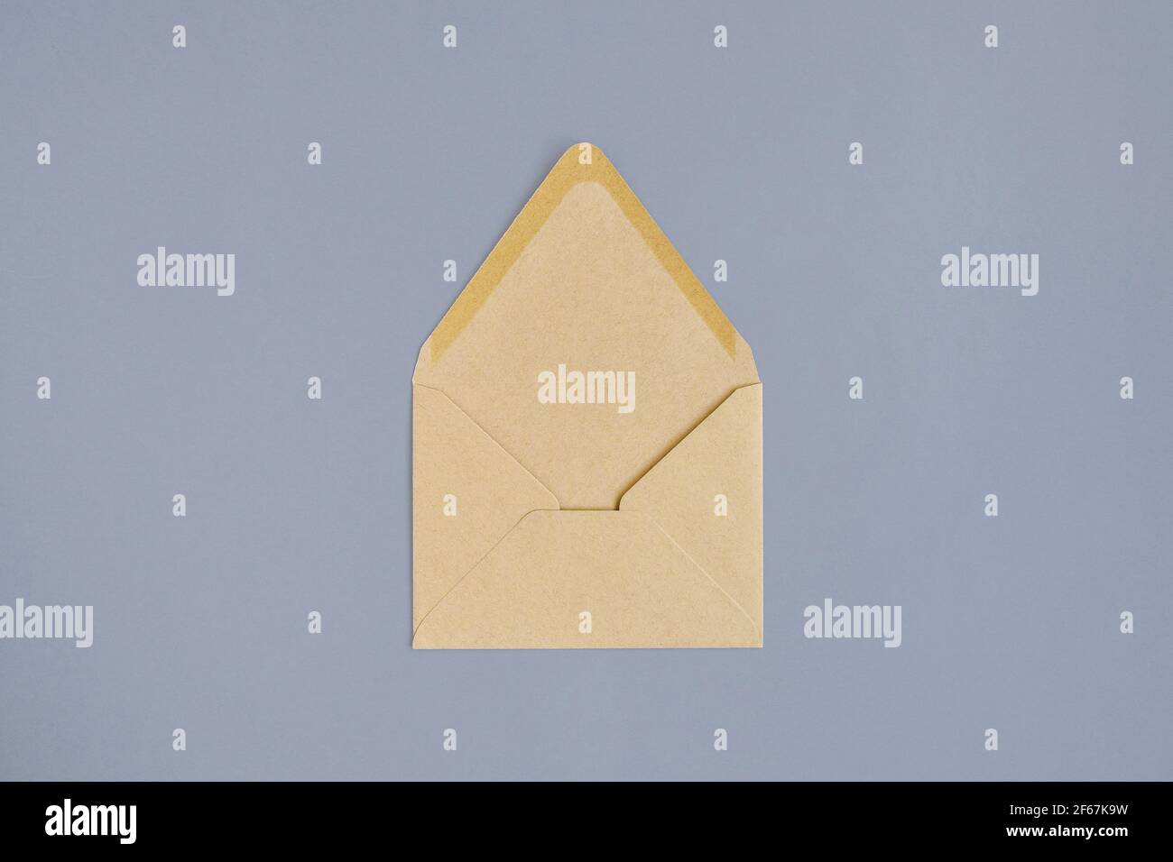 Open empty envelope made of craft paper on gray background. Close-up ...