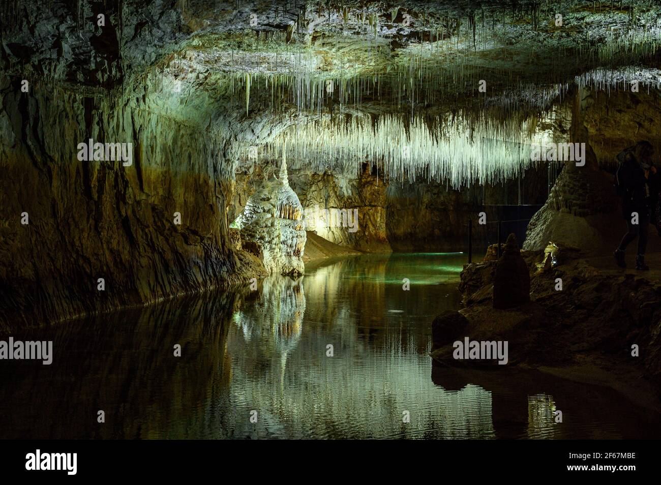 Water surface in underground cave. Rich stalactite decoration hanging ...