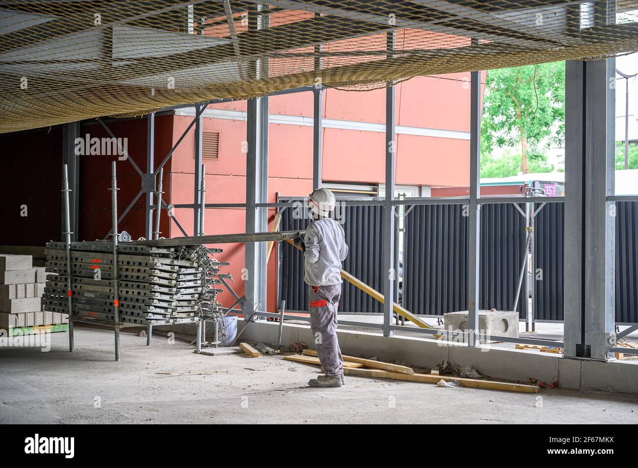Construction worker in dungarees manipulation with part of scaffolding ...