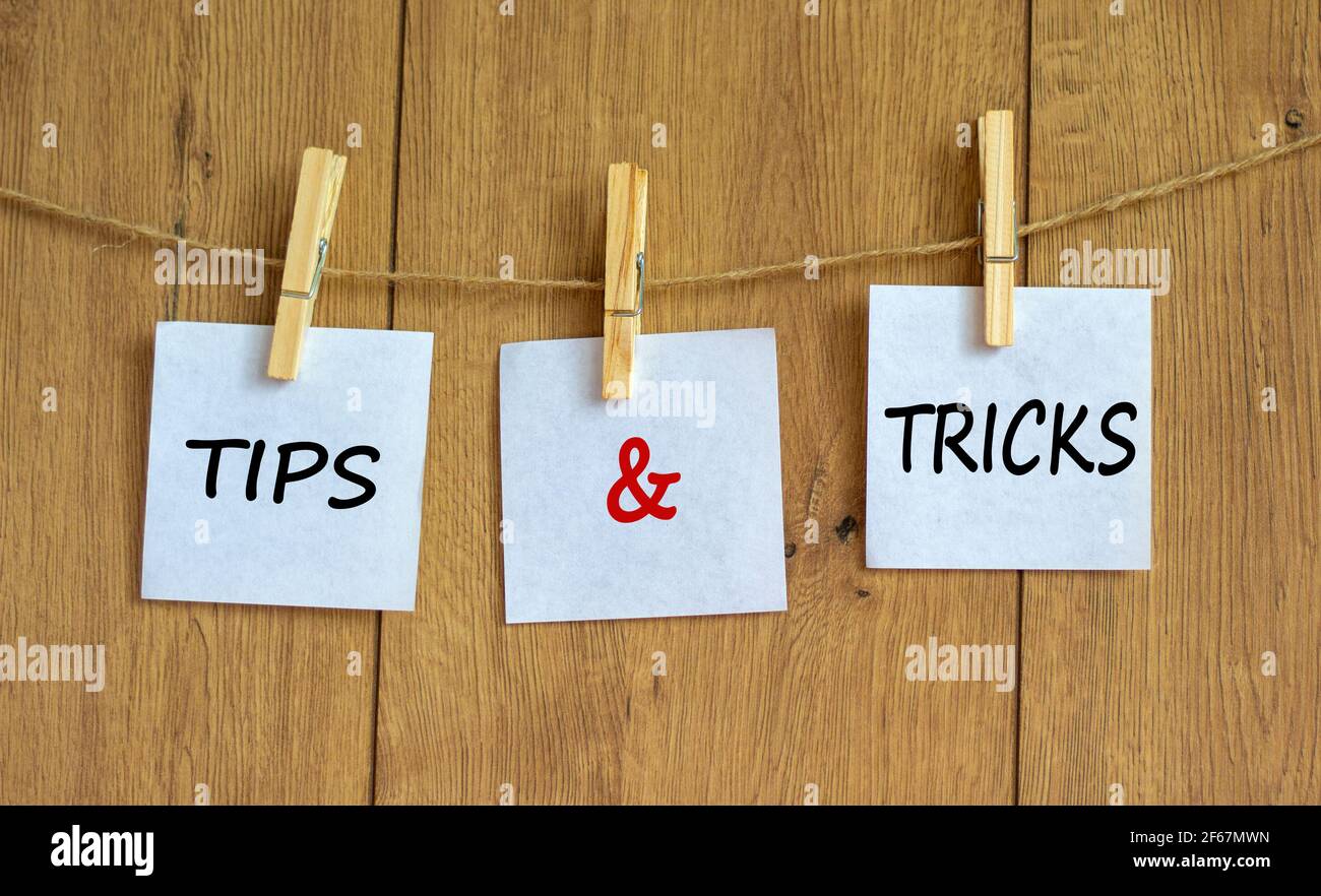 Tips and tricks symbol. White papers on wooden clothespins. Words 'Tips ...