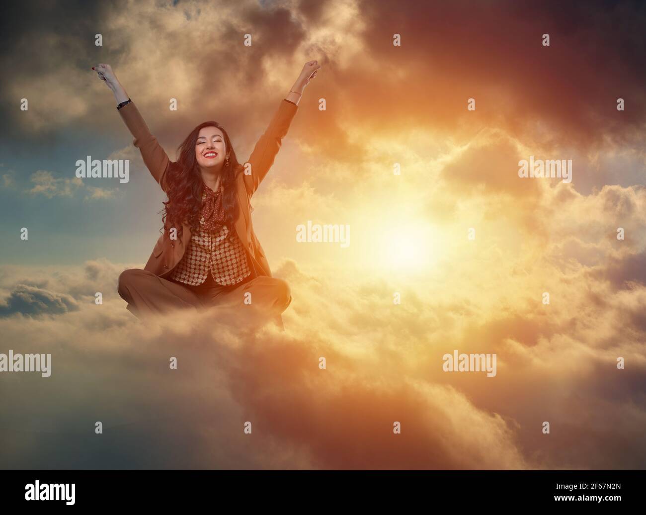 Happy excited businesswoman floating up in the sky on fluffy clouds ...