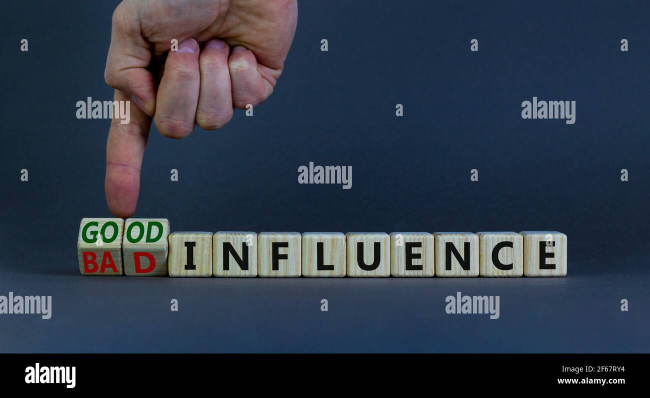 Good or bad influence symbol. Businessman turns cubes and changes words ...