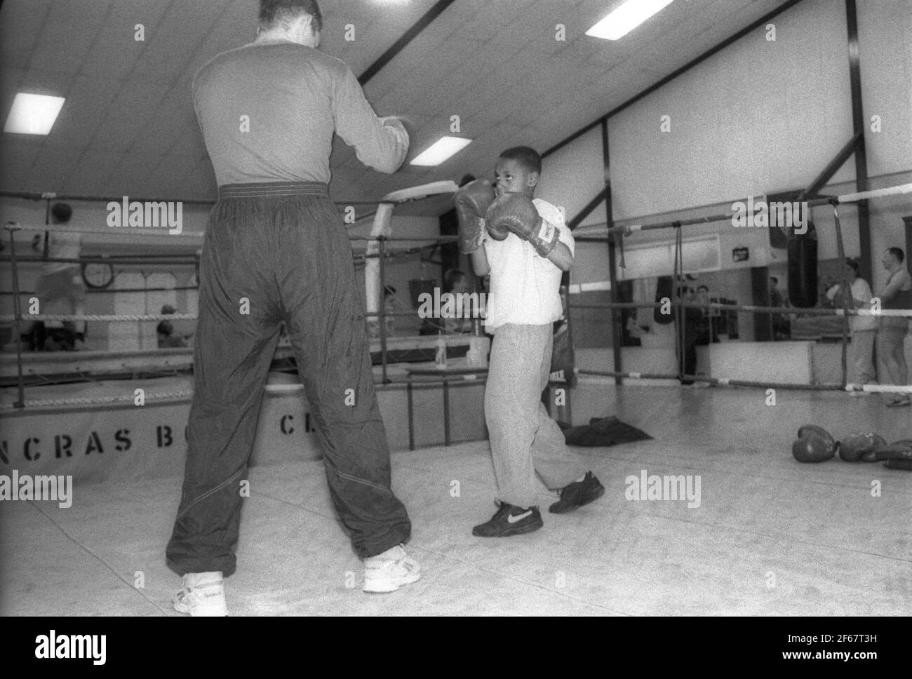 Young boxer working with his trainer at boxing club Stock Photo - Alamy