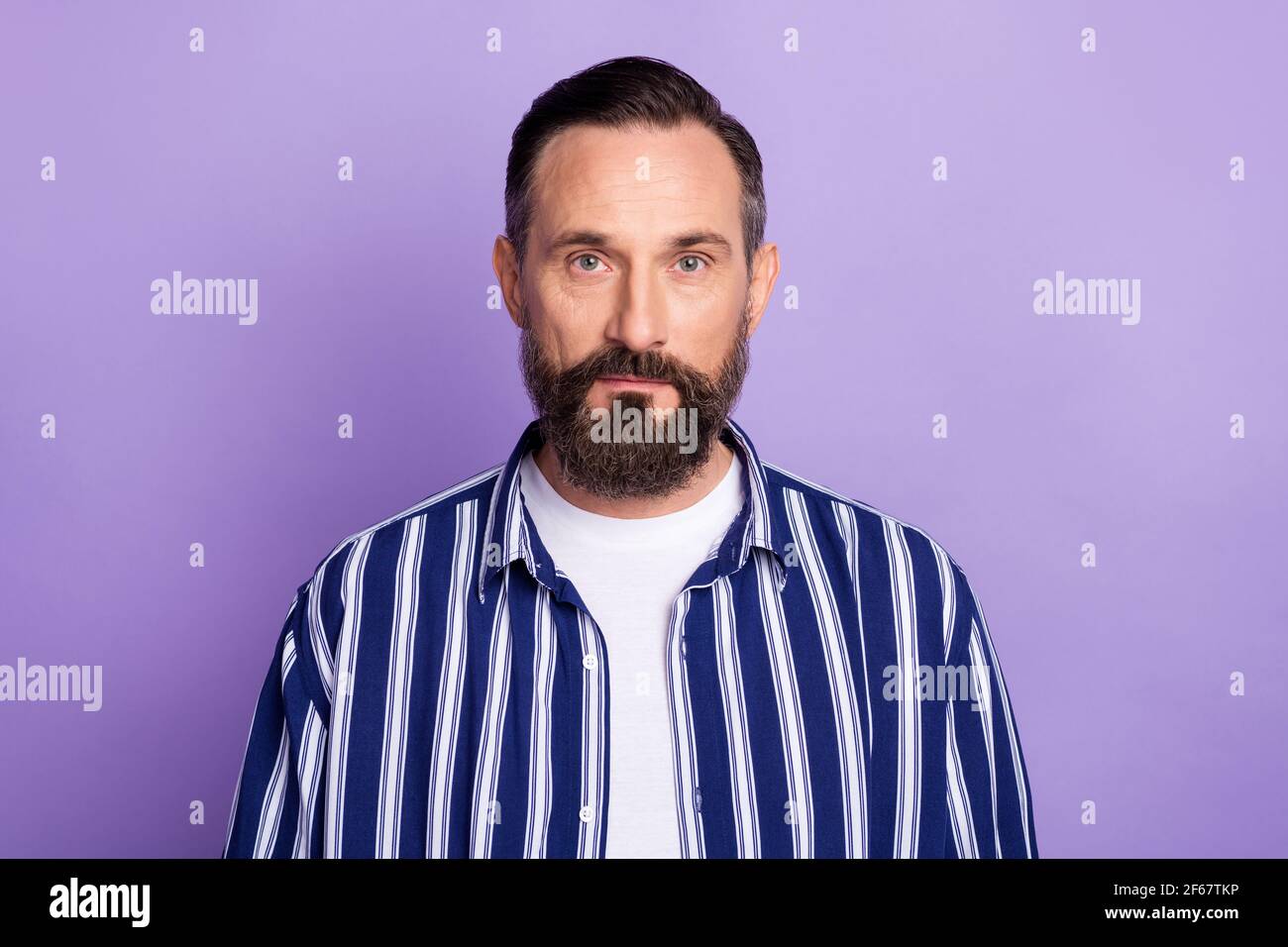 Photo of serious mature man look in camera isolated over purple color ...