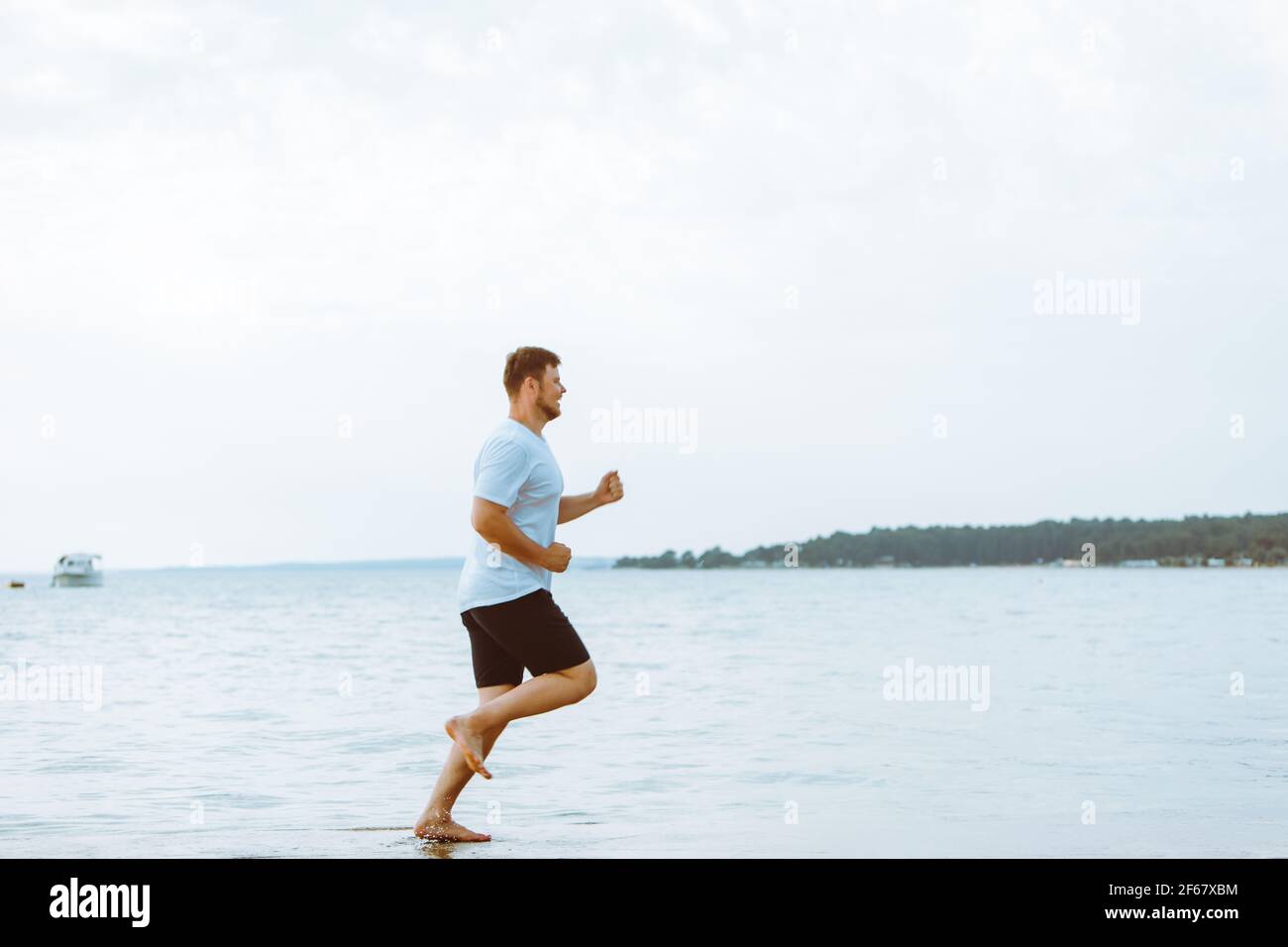 Man barefoot running beach handsome hi-res stock photography and images ...