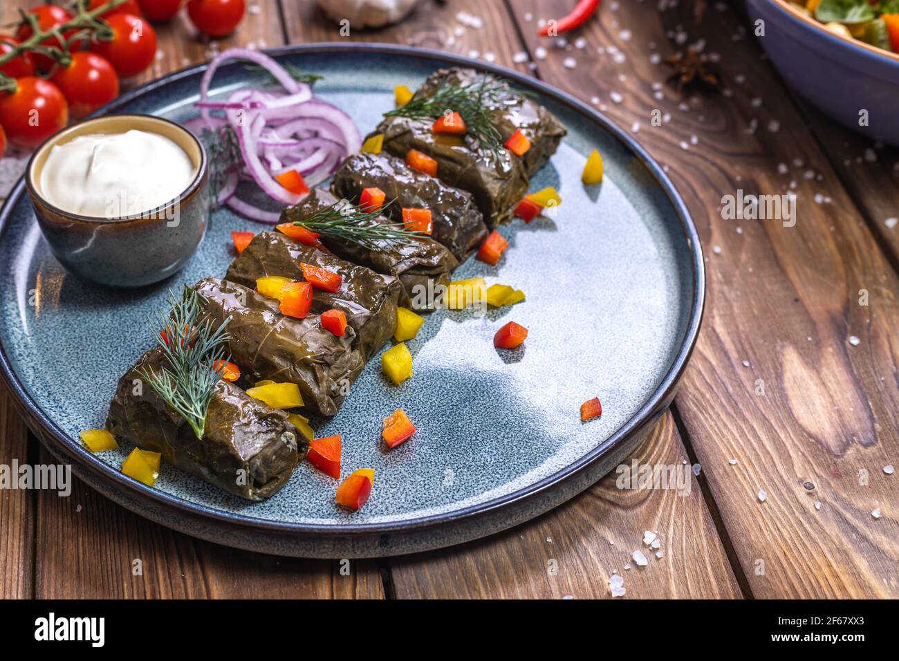 Dolma in grape leaves on a platter on a brown wooden background ...