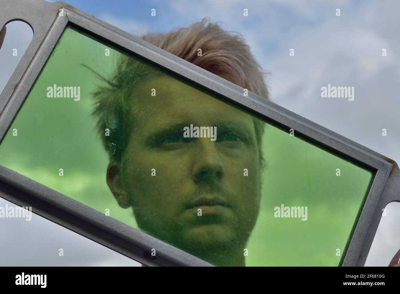 Dramatic Portrait of Young Man Looking Through a Pane of Coloured Glass ...