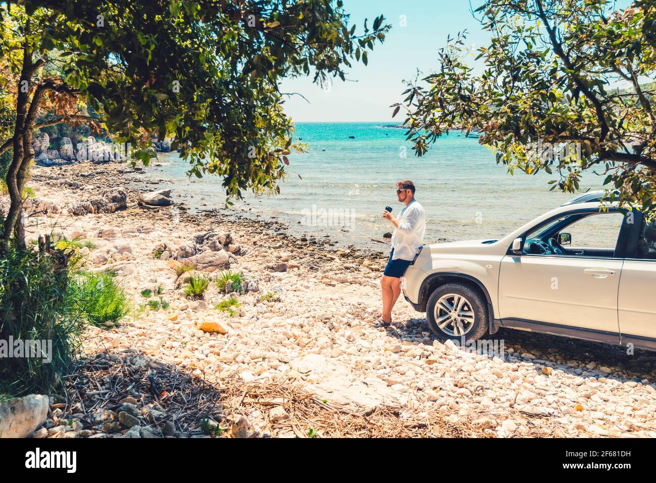 man with coffee cup standing near car at sea summer beach Stock Photo ...