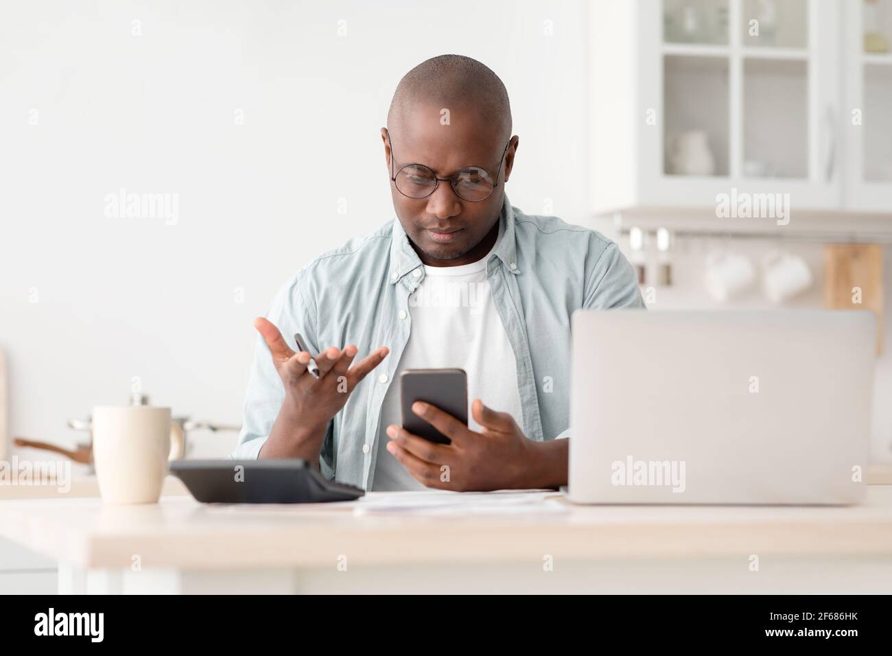 Financial problem. Angry african american man calculating utility ...