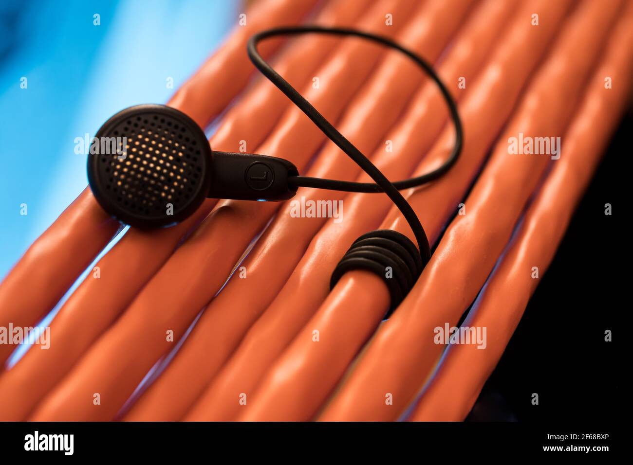 Listening device on orange data cables against a blue background Stock ...