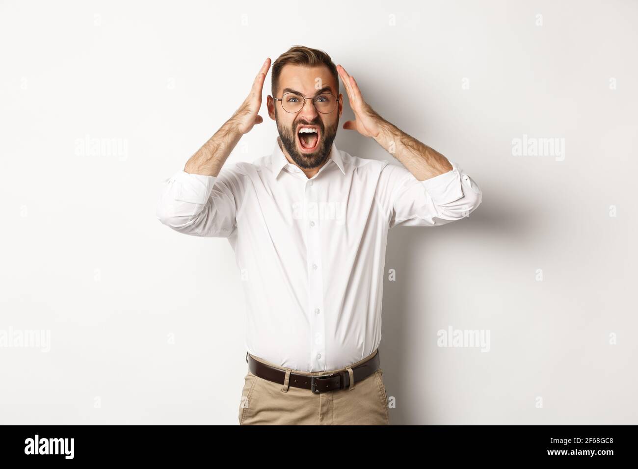Frustrated man panicking, shouting and looking anxious, standing over ...