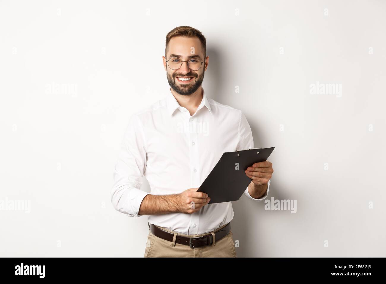 Handsome manager in glasses working, using clipboard, standing over ...