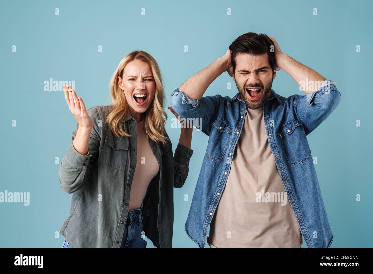 Young irritated man and woman screaming while having argument isolated ...