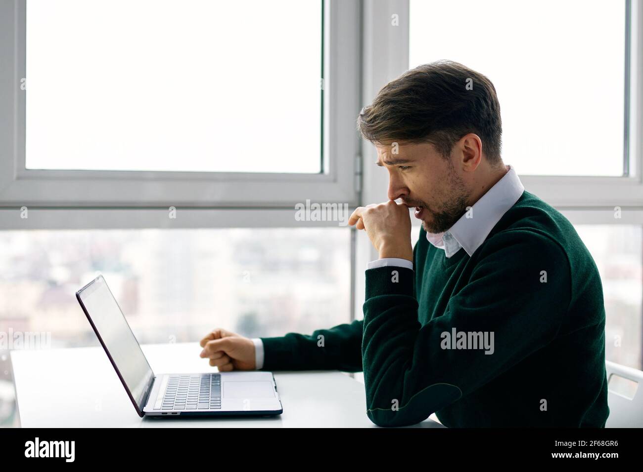 business man sitting at his desk in front of a laptop work is the ...