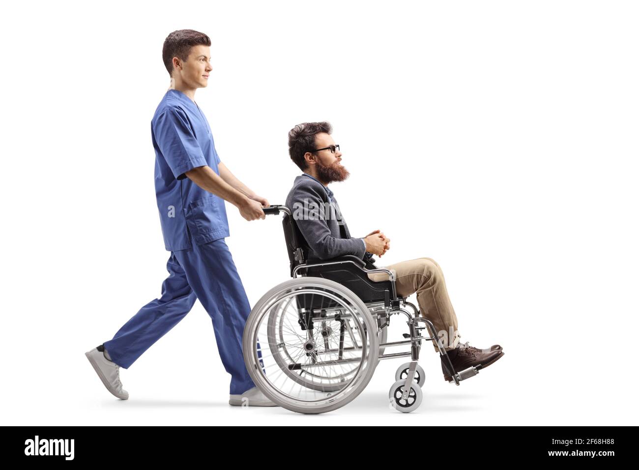 Full length profile shot of a young male nurse pushing a man in a ...