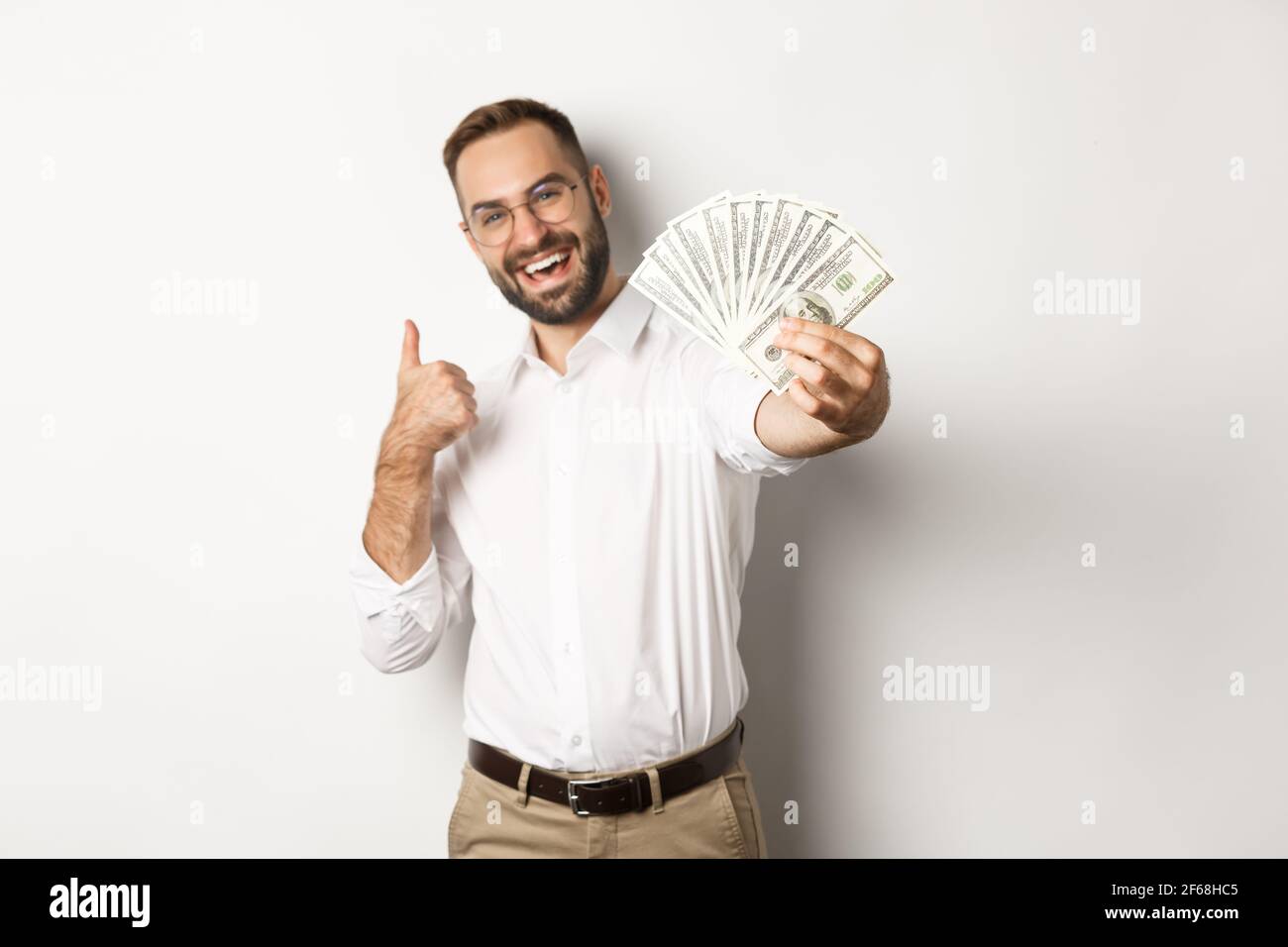 Successful businessman showing money dollars and thumbs-up, smiling ...
