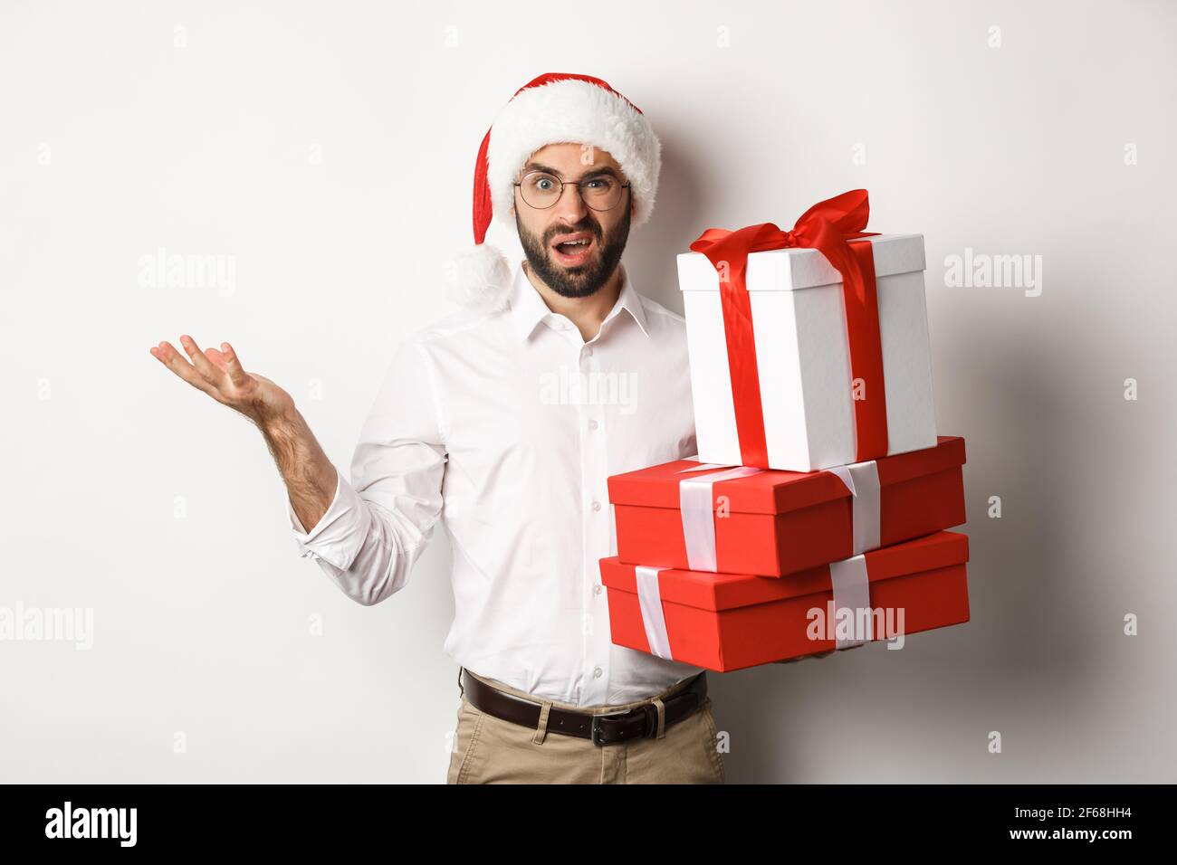 Merry christmas, holidays concept. Man looking confused while holding ...