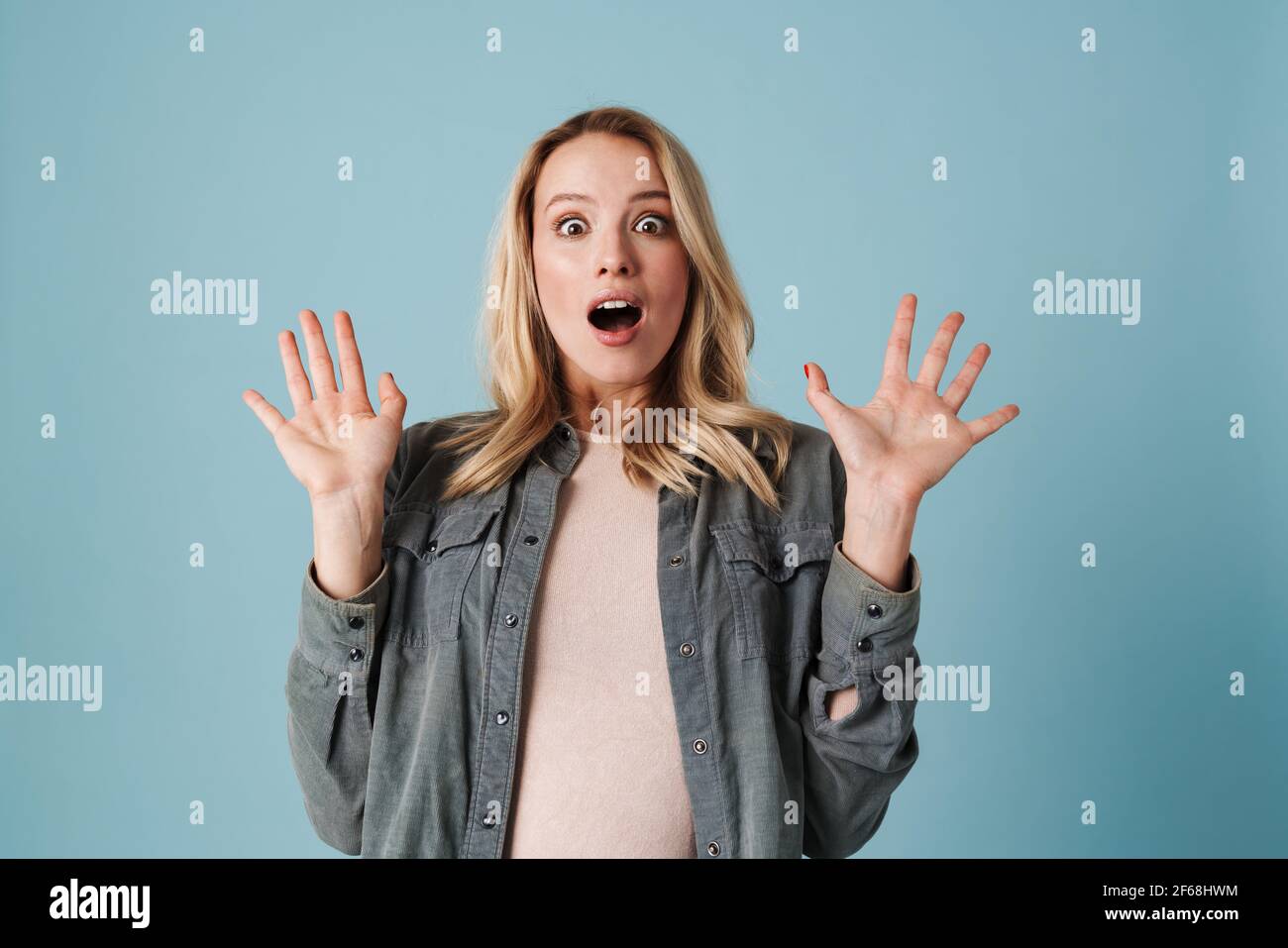 Happy beautiful shocked girl expressing surprise with hands up isolated ...