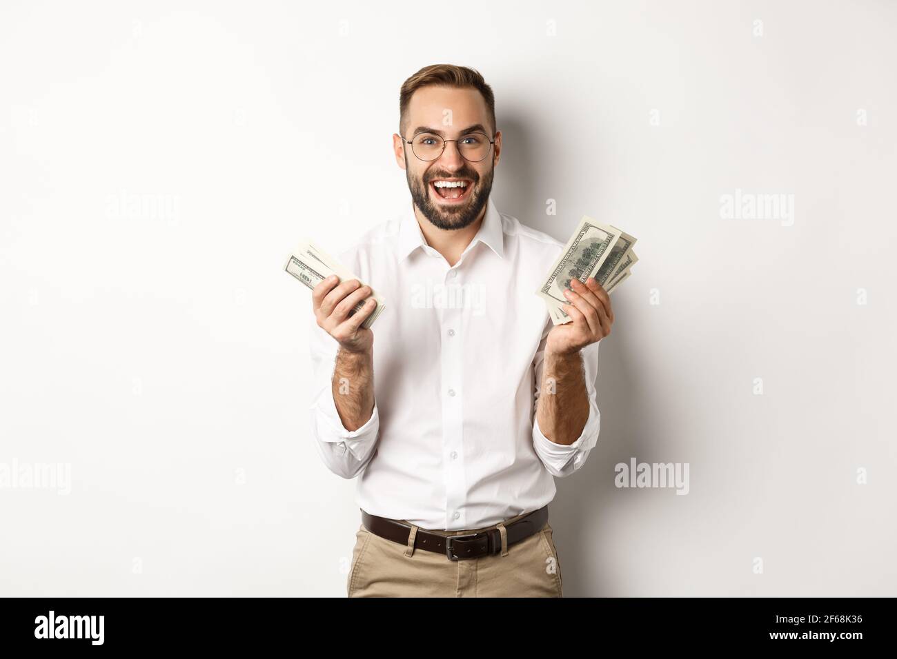 Handsome successful business man counting money, rejoicing and smiling ...