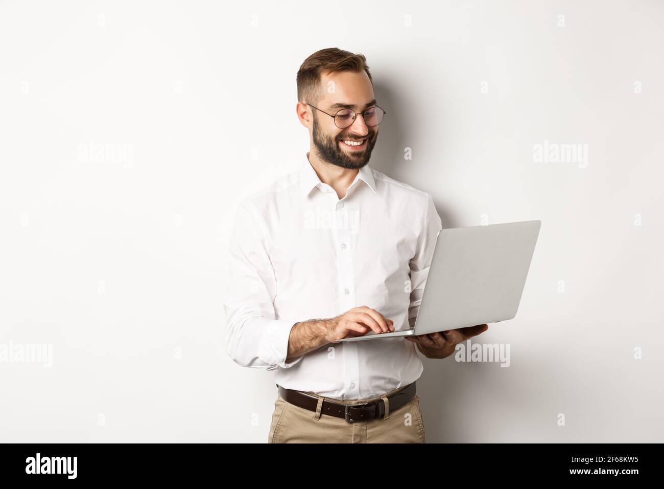 Business. Handsome businessman working on laptop, answering messages ...