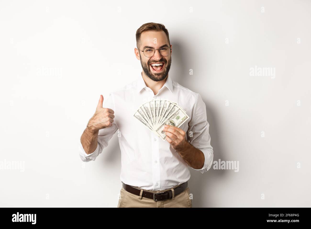 Excited rich man holding money, showing thumb up in approval, standing ...