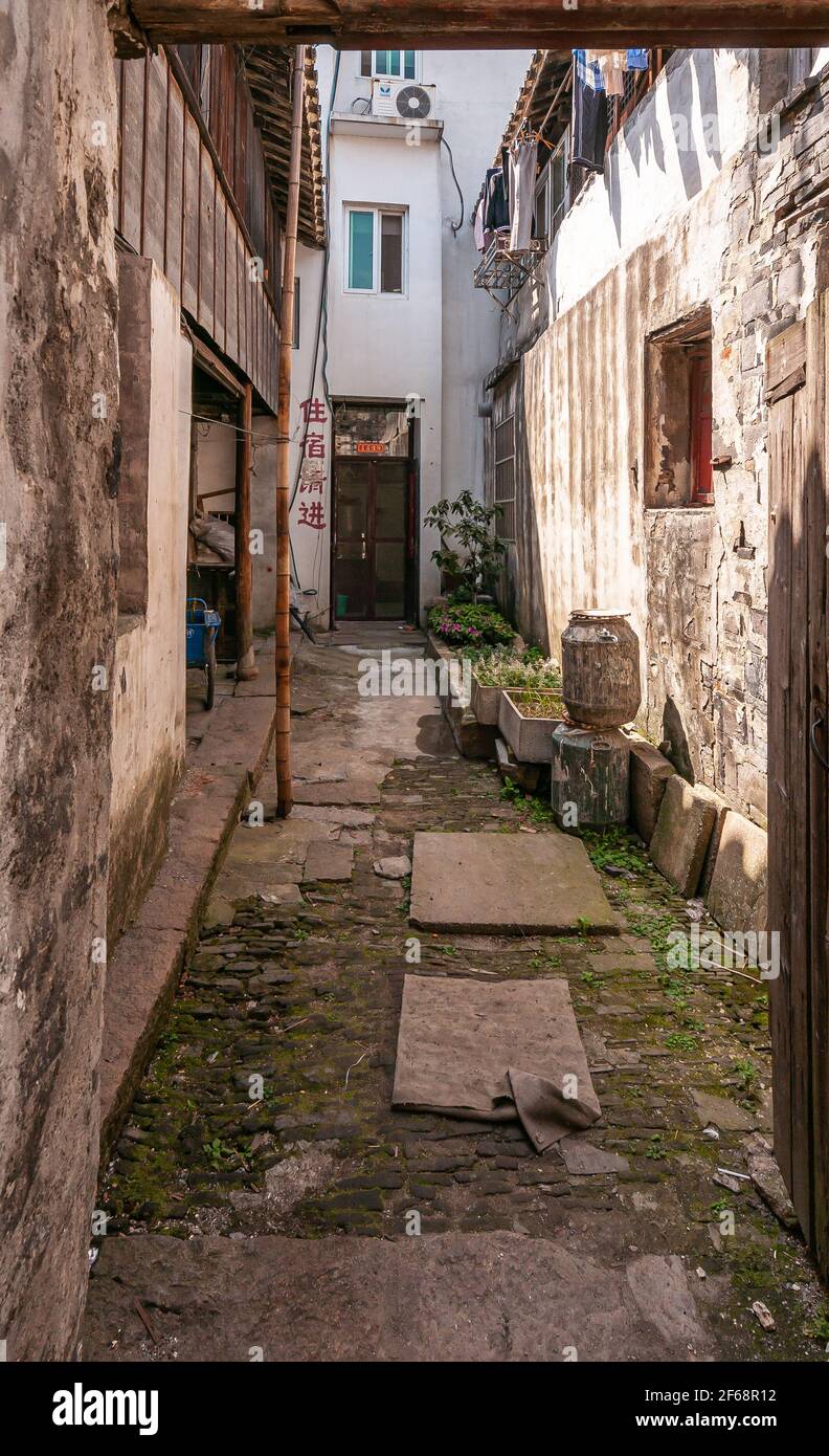 Tongli, China - May 2, 2010: View in narrow dead-end alley with weeds ...